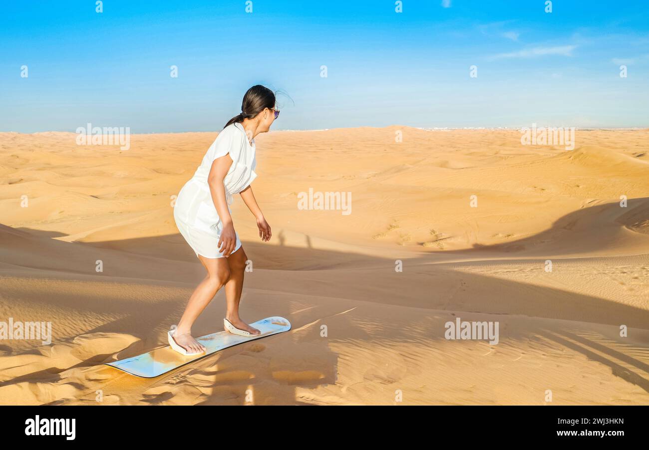 Young women sand surfing at the sand dunes of Dubai United Arab ...