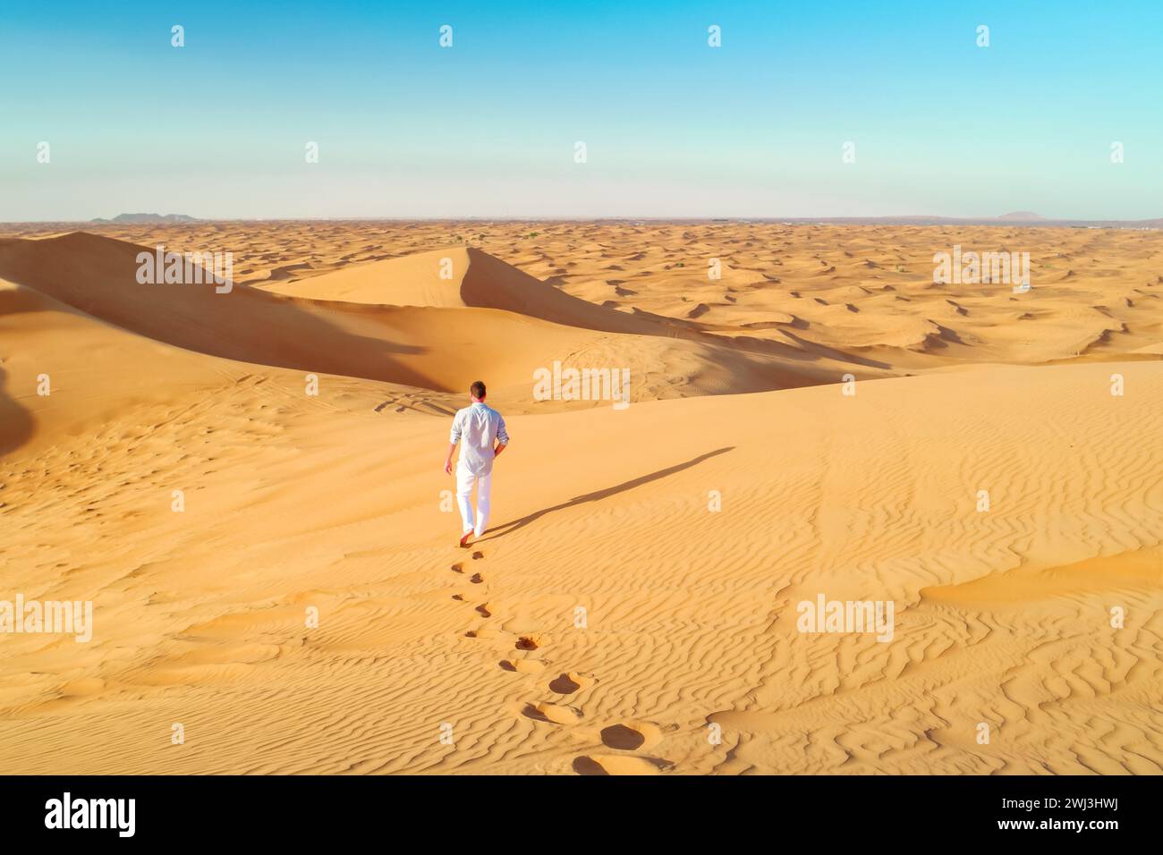 Dubai desert sand dunes, young men walking at the sand dunes of Dubai ...