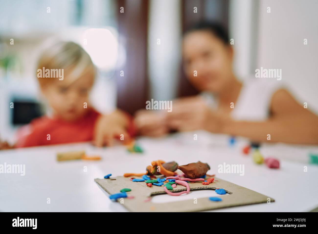 Figurines of various shapes made of plasticine lies on the board ...