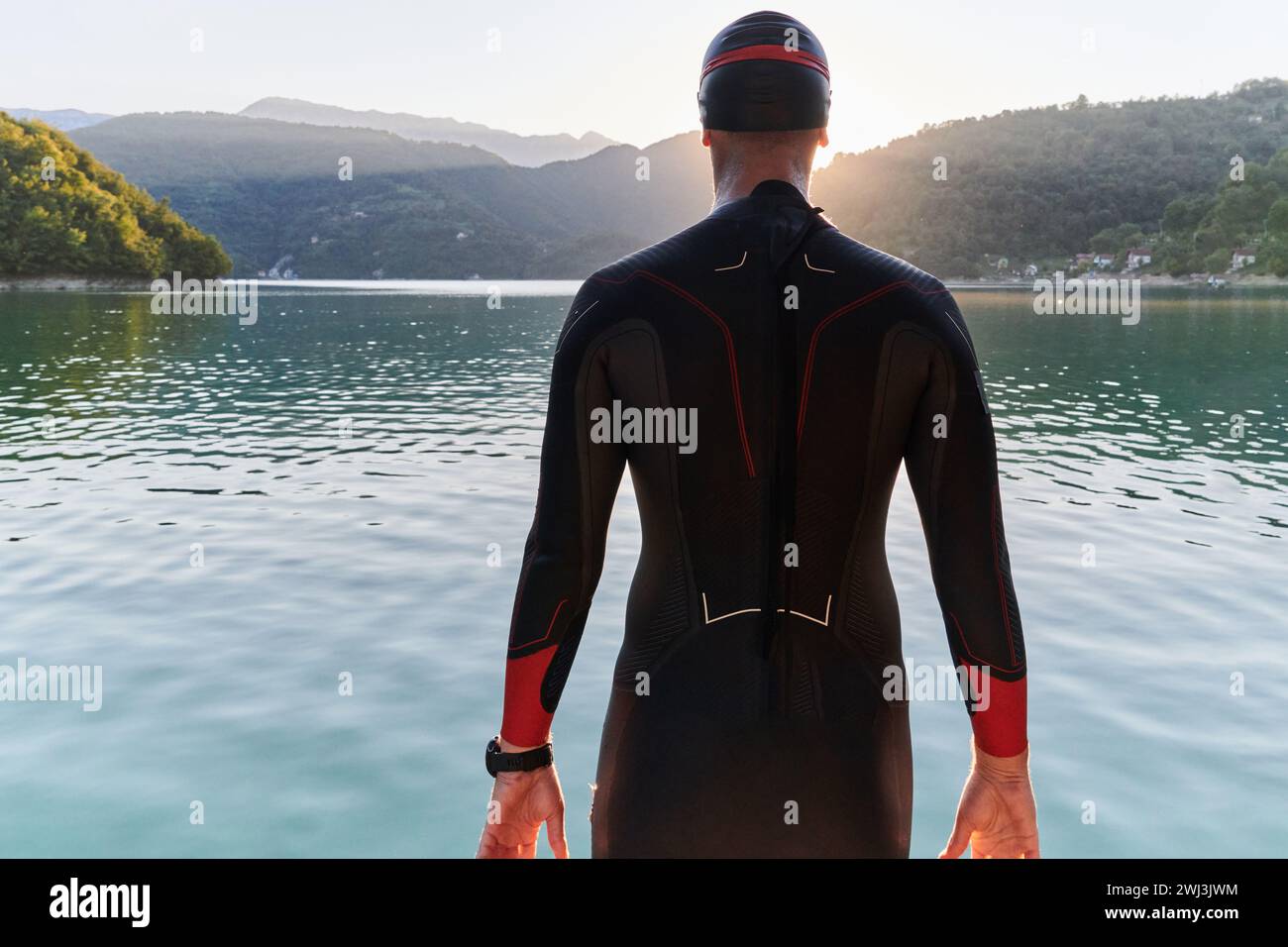 Authentic triathlon athlete getting ready for swimming training on lake ...