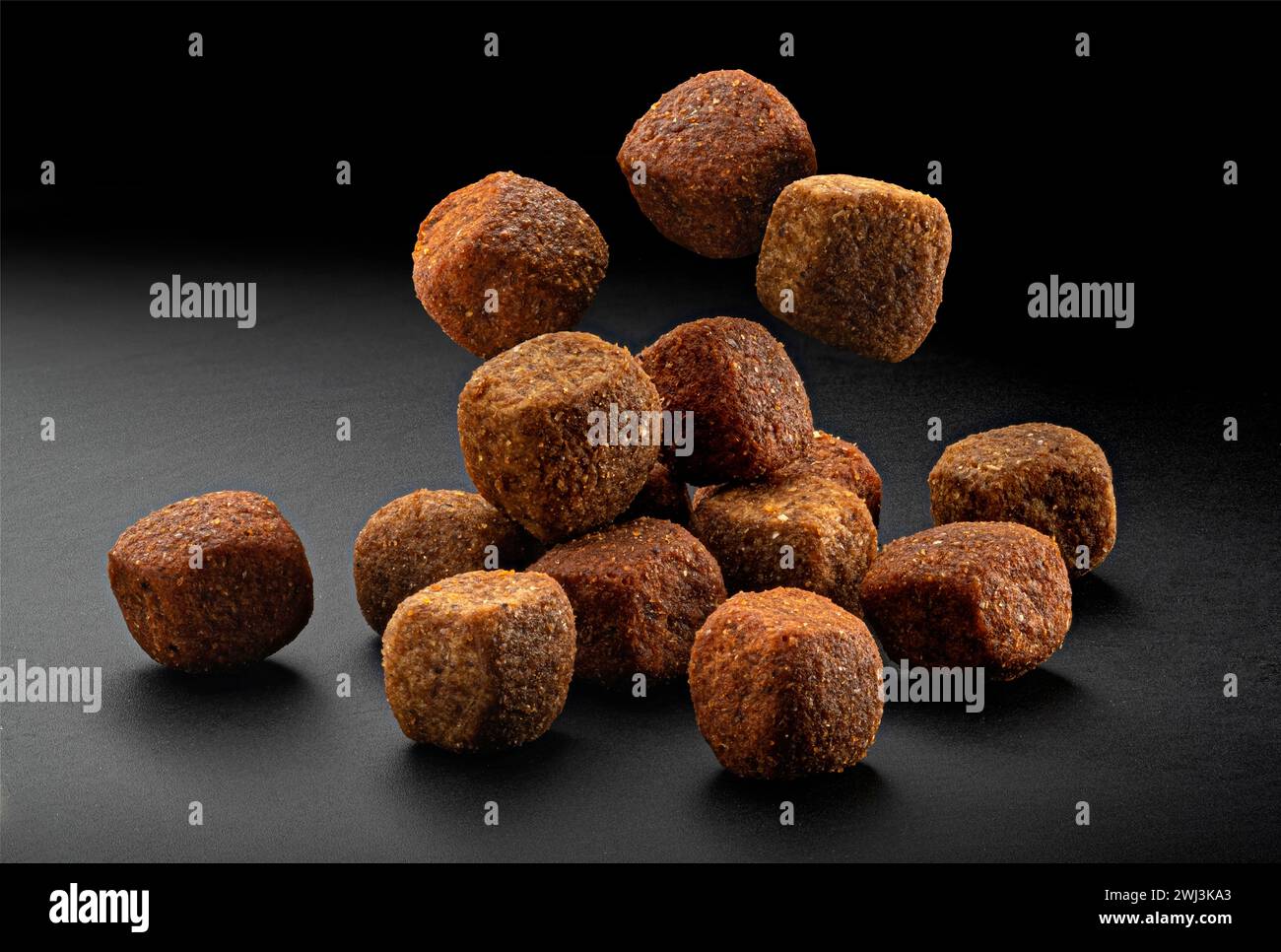 Falling dry pet food on black background with copy space Stock Photo ...