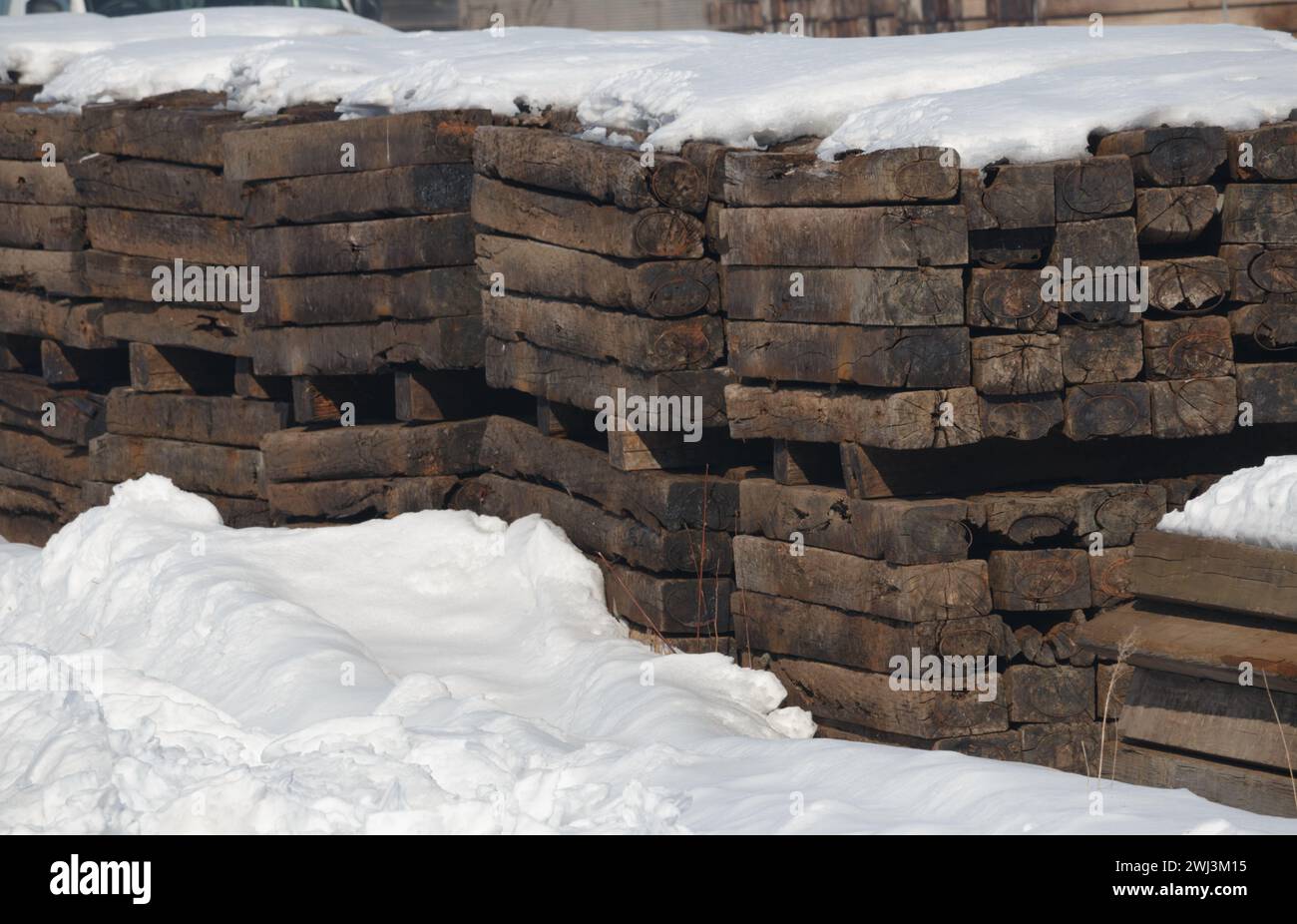 Stacks of old vintage wooden railway sleepers surrounded by snow Stock ...