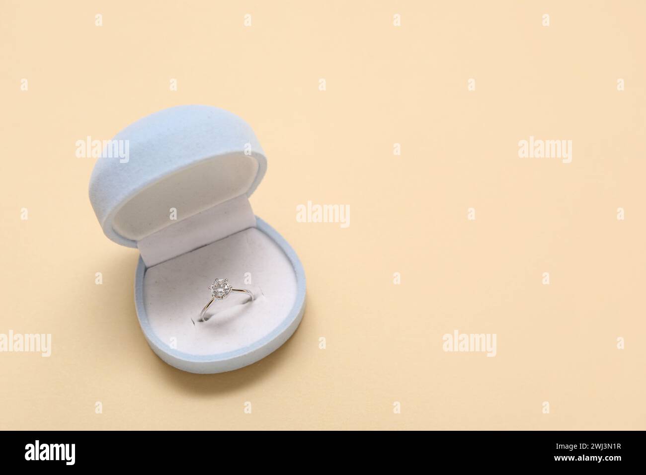 Box with beautiful engagement ring on beige background Stock Photo - Alamy
