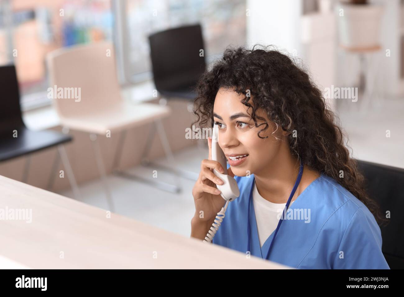 Female African-American medical intern talking by telephone at ...
