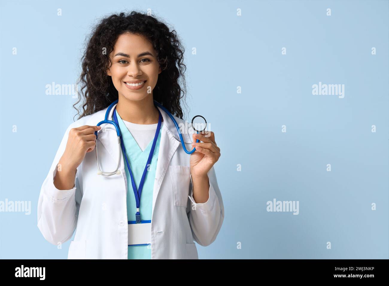 Female African-American medical intern with stethoscope on blue ...