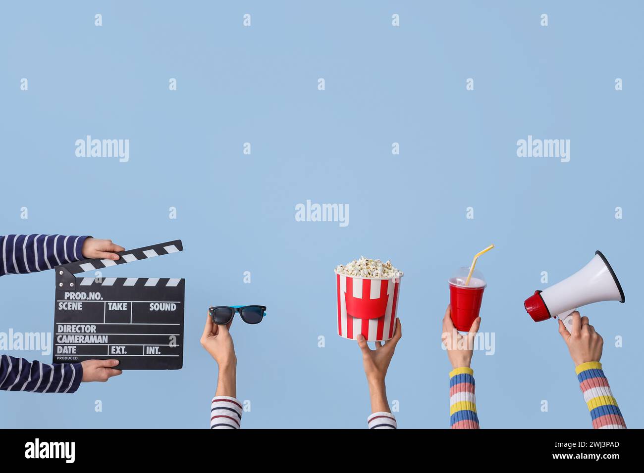 Many hands with movie clapper, bucket of popcorn and megaphone on blue ...