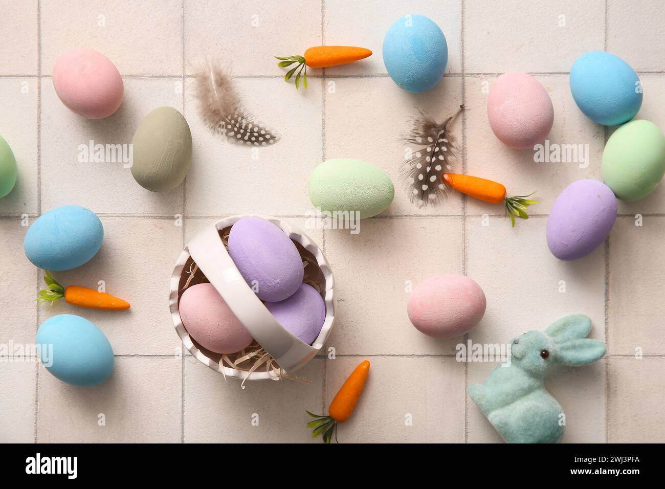 ceramic-basket-with-painted-easter-eggs-feathers-and-bunny-on-white