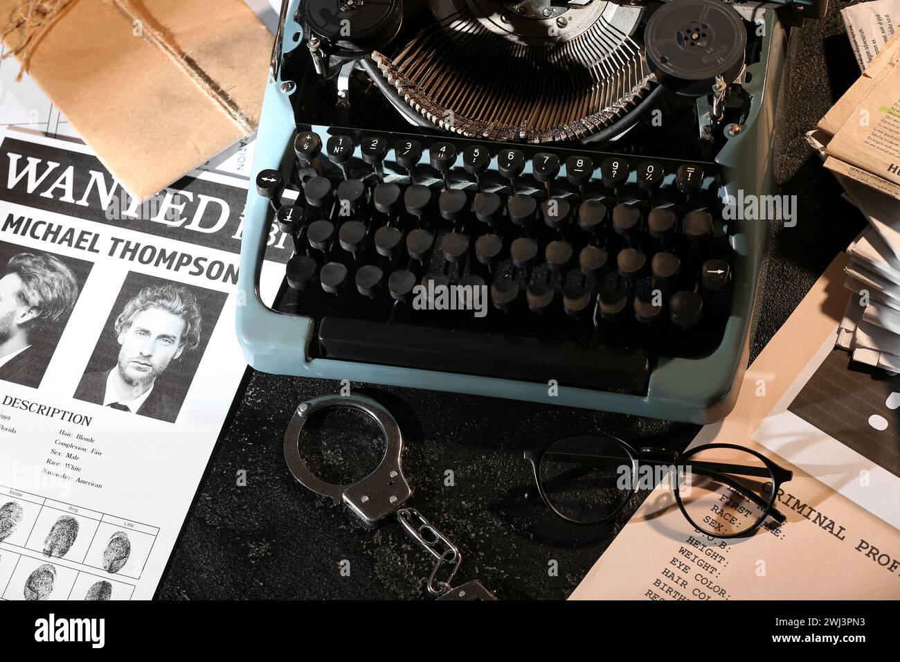 Retro typewriter, handcuffs, eyeglasses and criminal files on dark ...