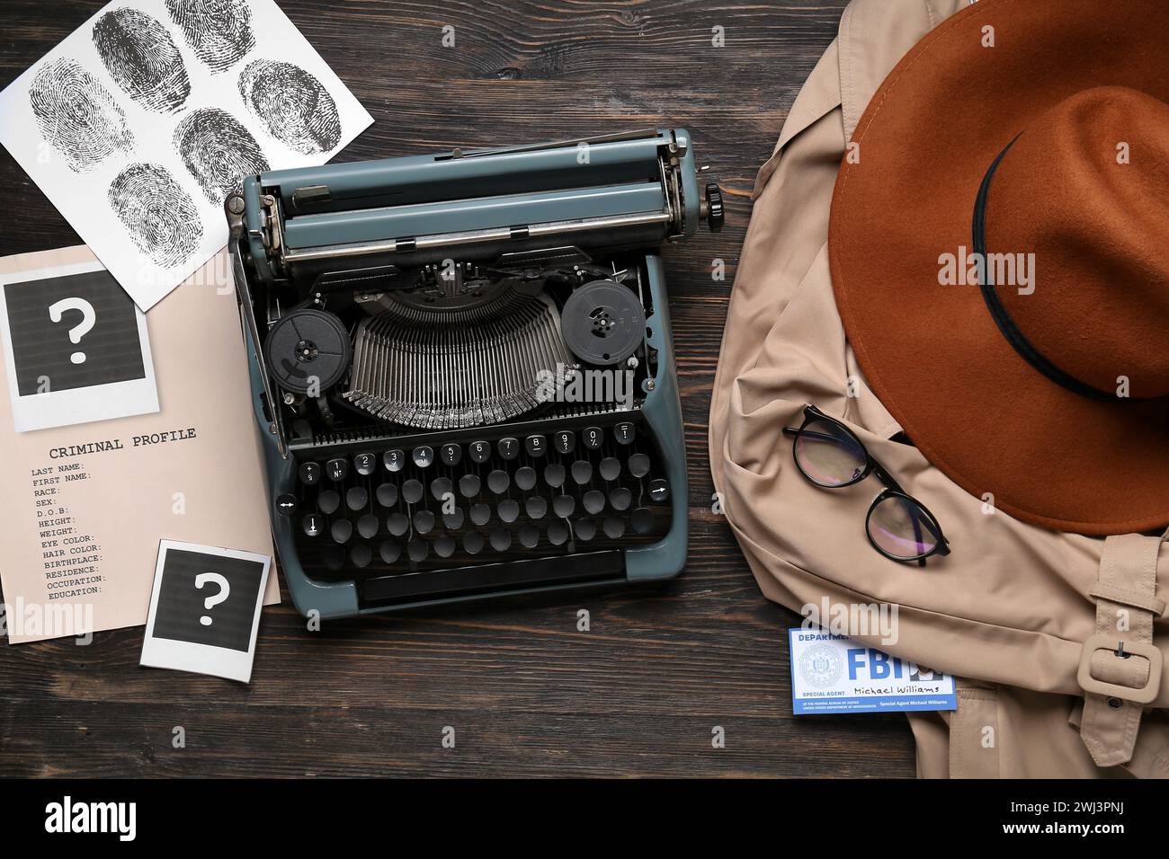 Composition with retro typewriter, criminal files and clothes on wooden ...