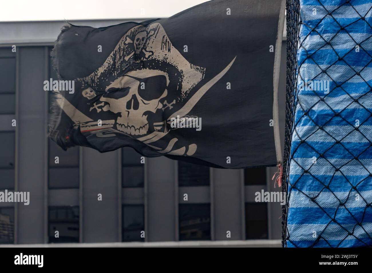 A pirate flag flies behind a moving pickup truck with cargo Stock Photo ...