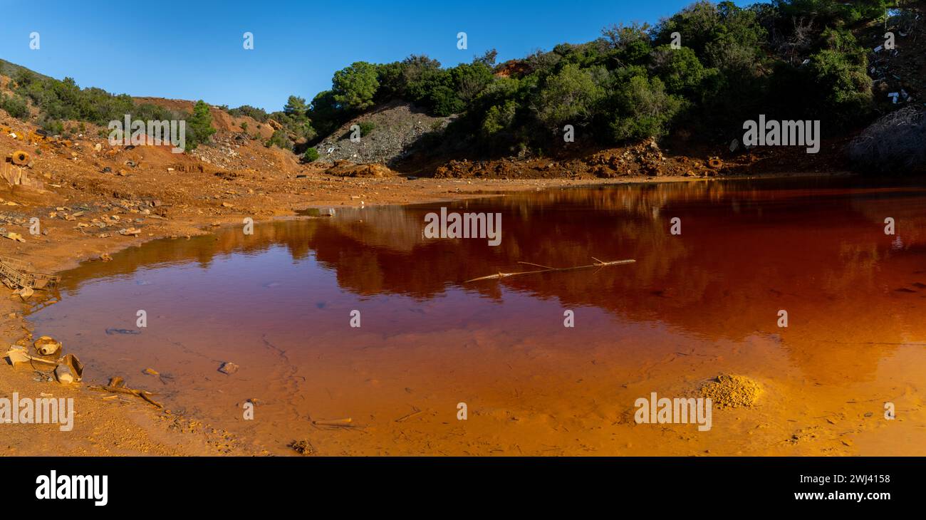 Landscape view of a red waste water pond in an abandoned iron ore mine ...