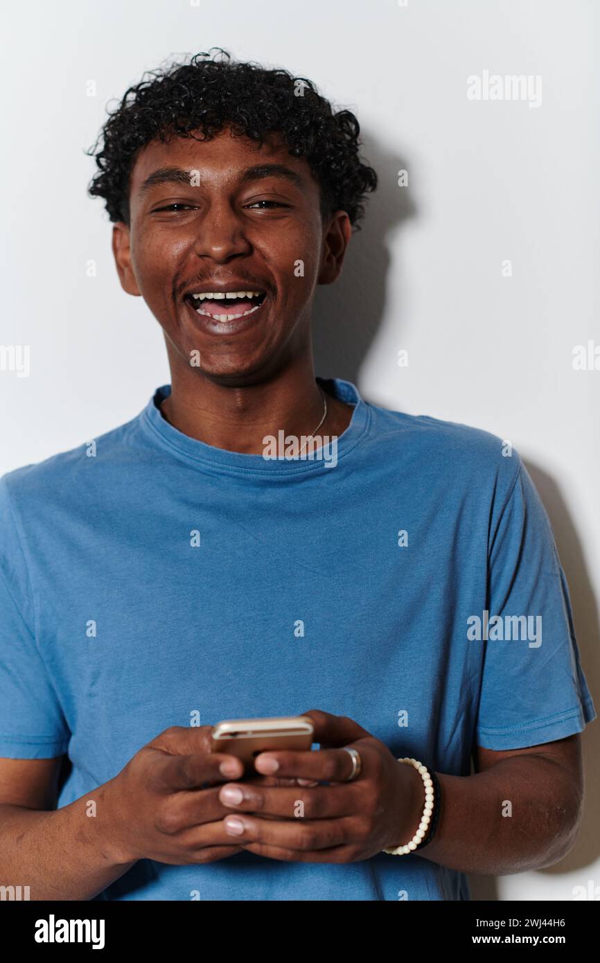 African American teenager engages with his smartphone against a ...