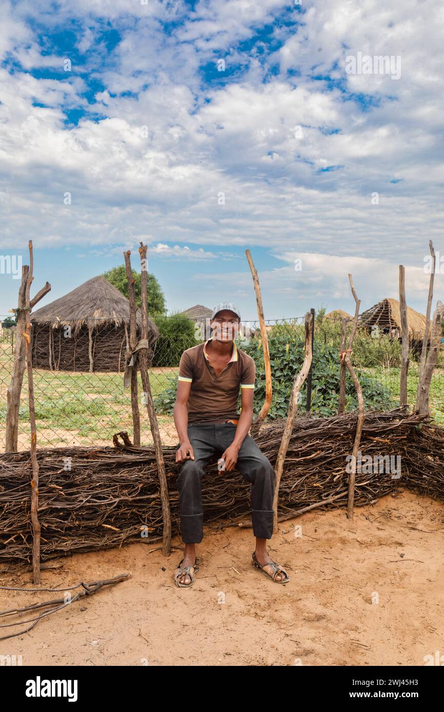 village african man portrait, standing outside in the yard on a wattle ...