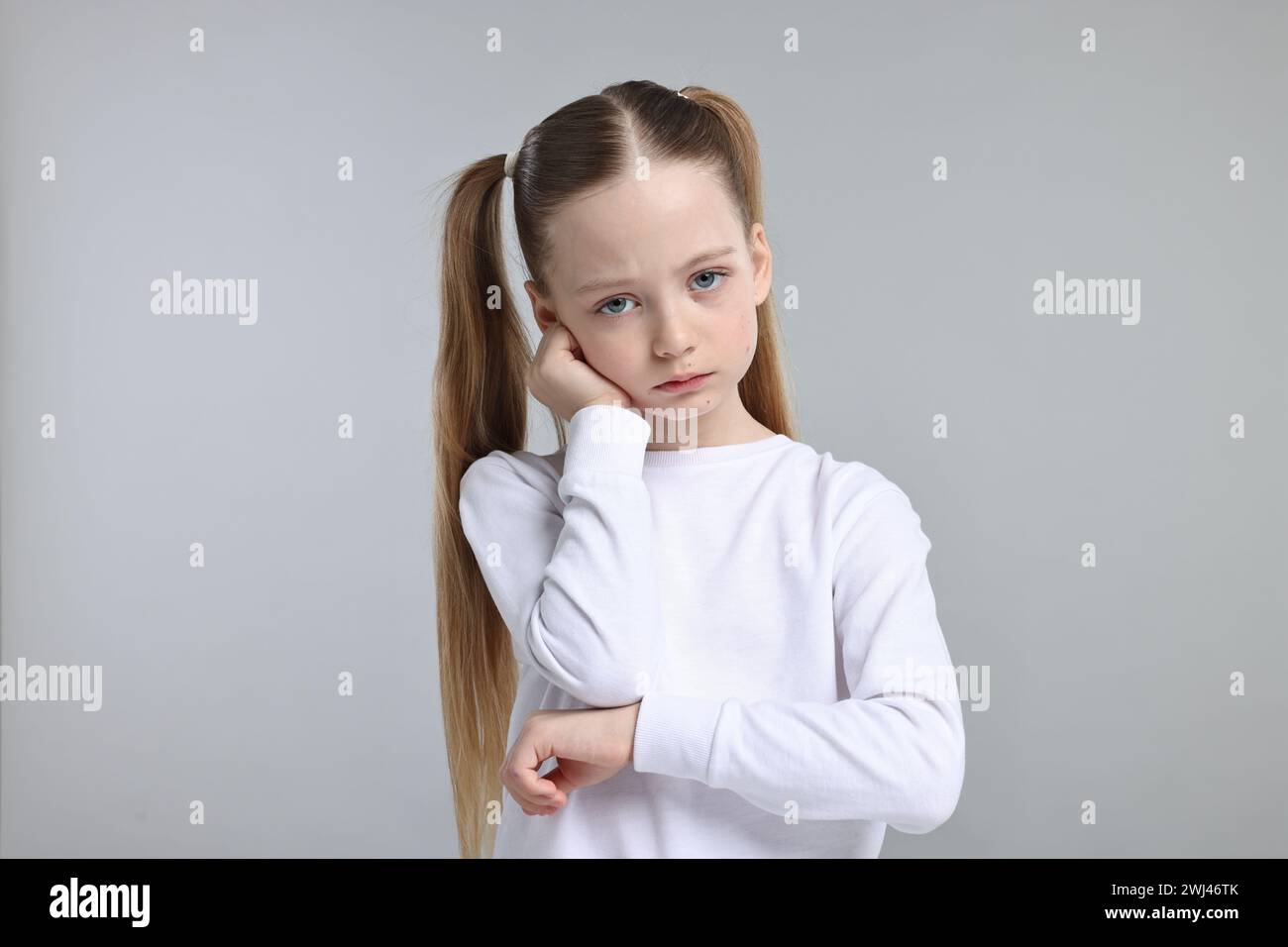 Portrait of sad girl on light grey background Stock Photo - Alamy