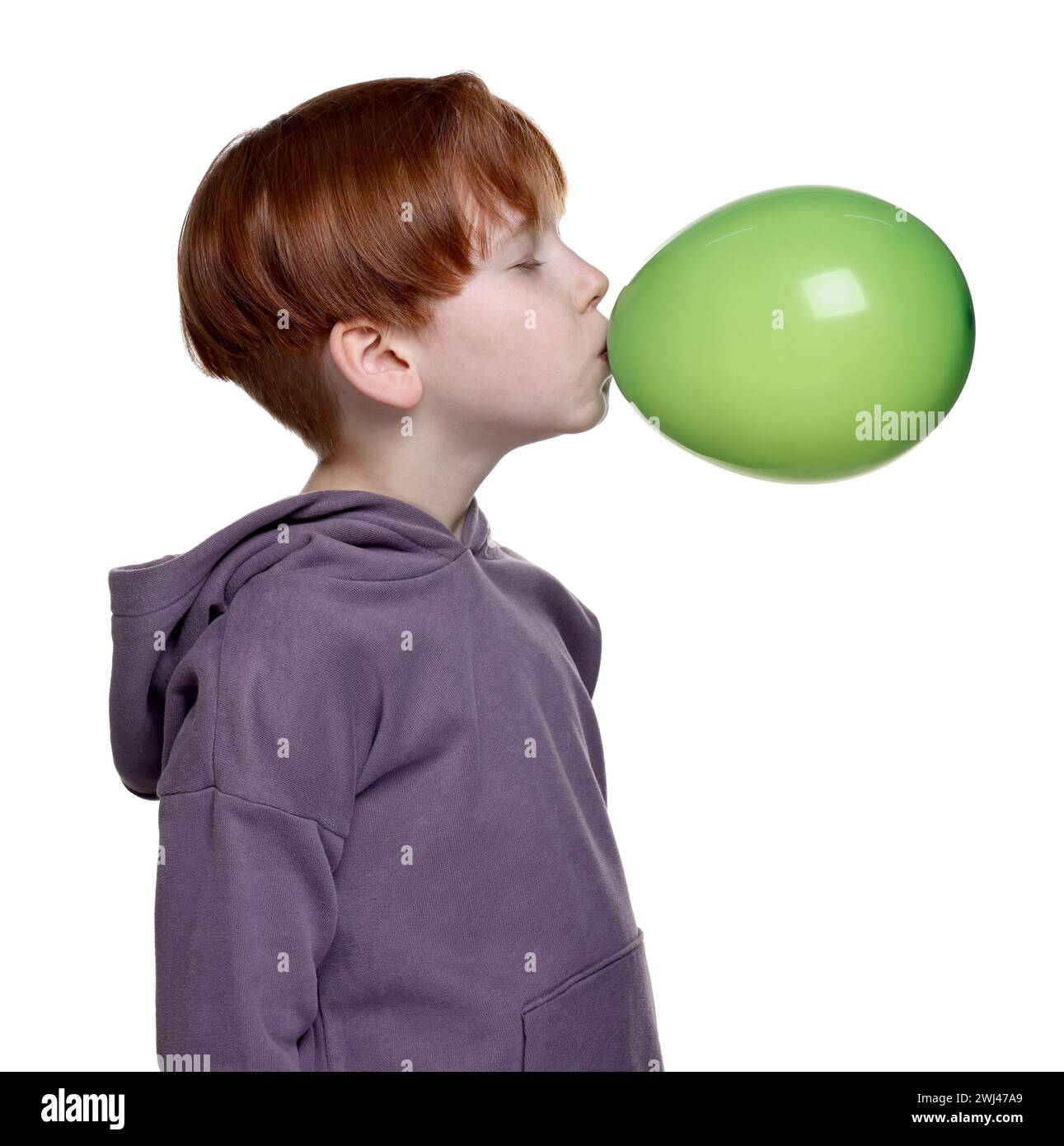 Boy inflating green balloon on white background Stock Photo - Alamy