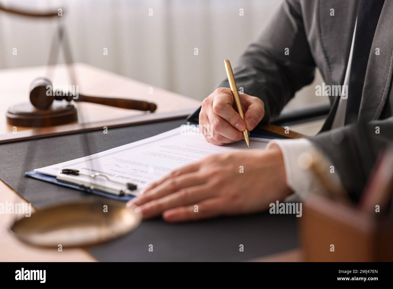 Notary writing notes at wooden table in office, closeup Stock Photo - Alamy