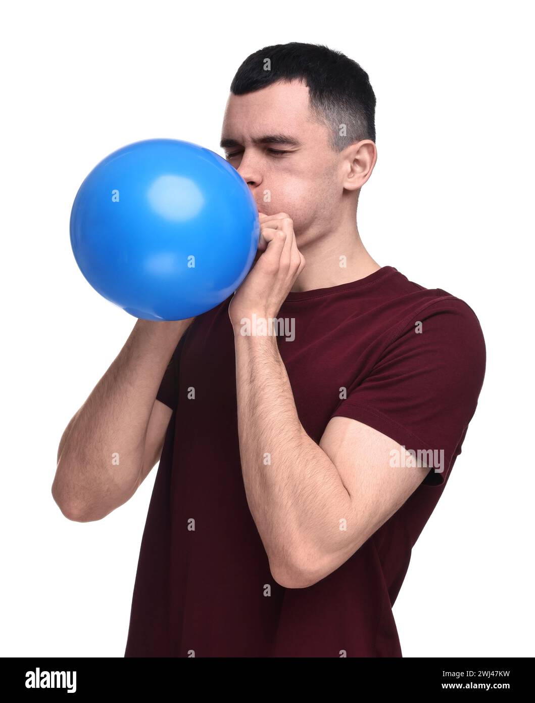 Young man inflating light blue balloon on white background Stock Photo ...
