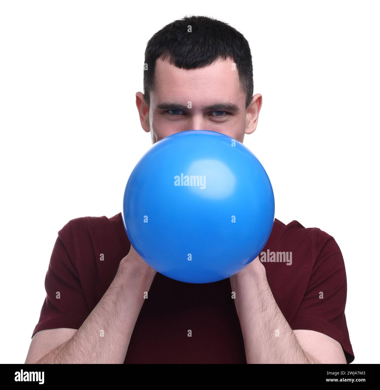 Young man inflating light blue balloon on white background Stock Photo ...