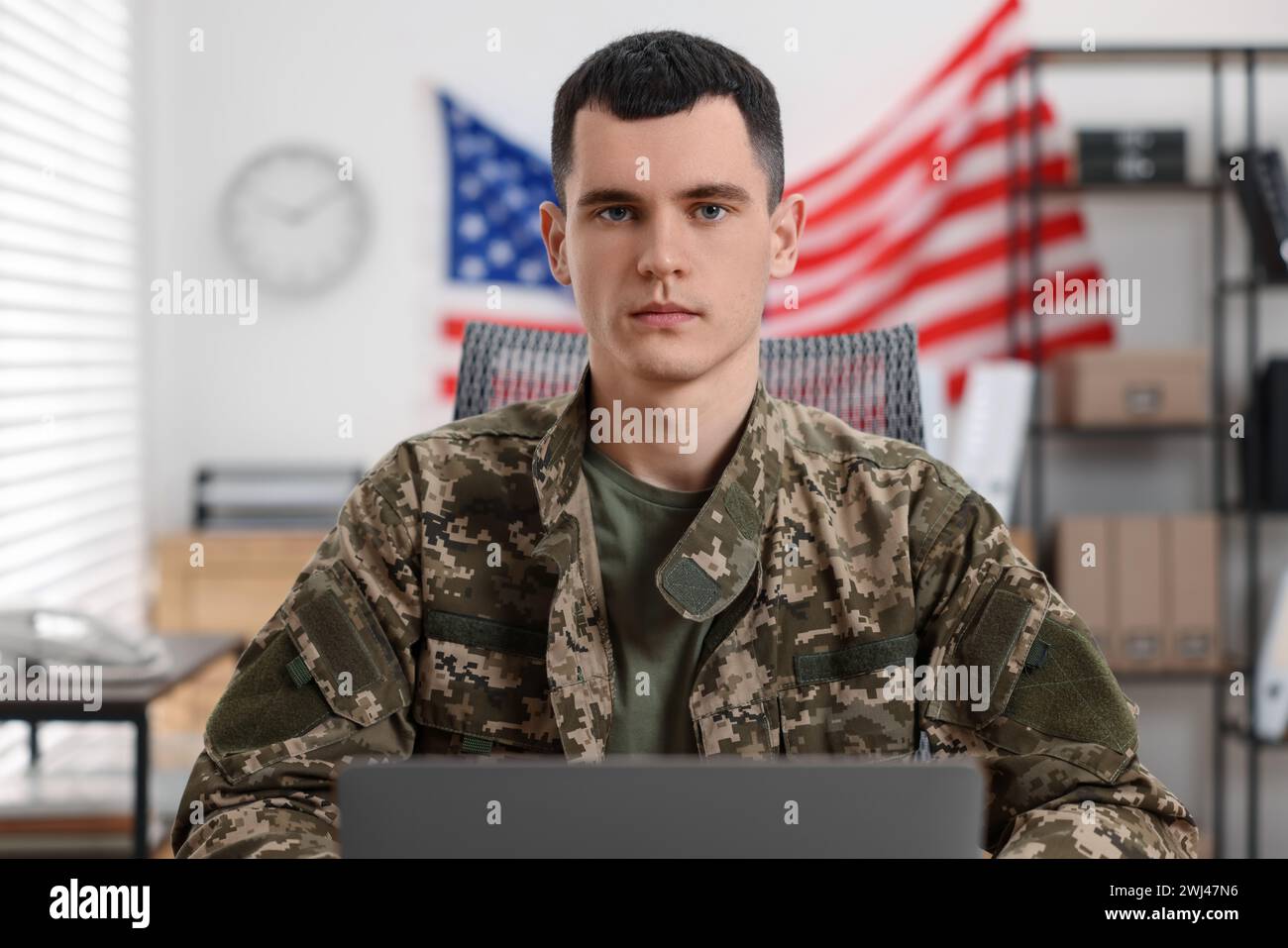 Military service. Young soldier working in office Stock Photo - Alamy