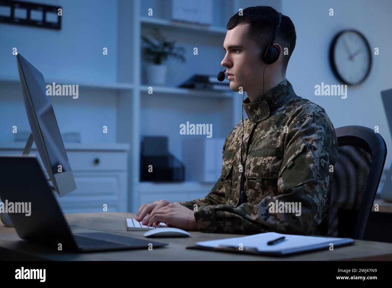 Military service. Young soldier in headphones working at table in ...