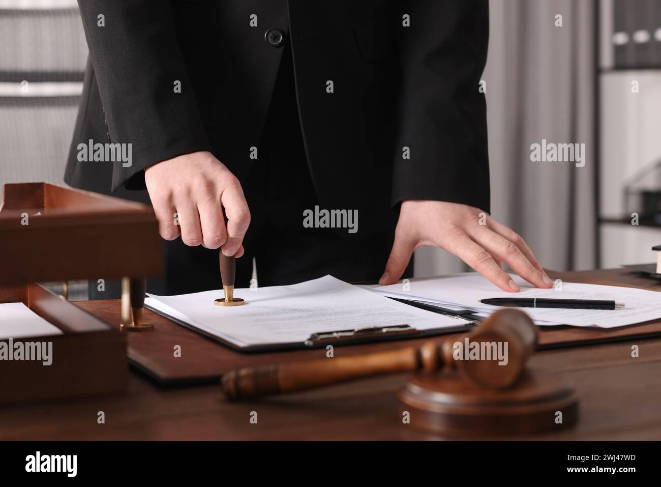 Notary stamping document at wooden table in office, closeup Stock Photo ...
