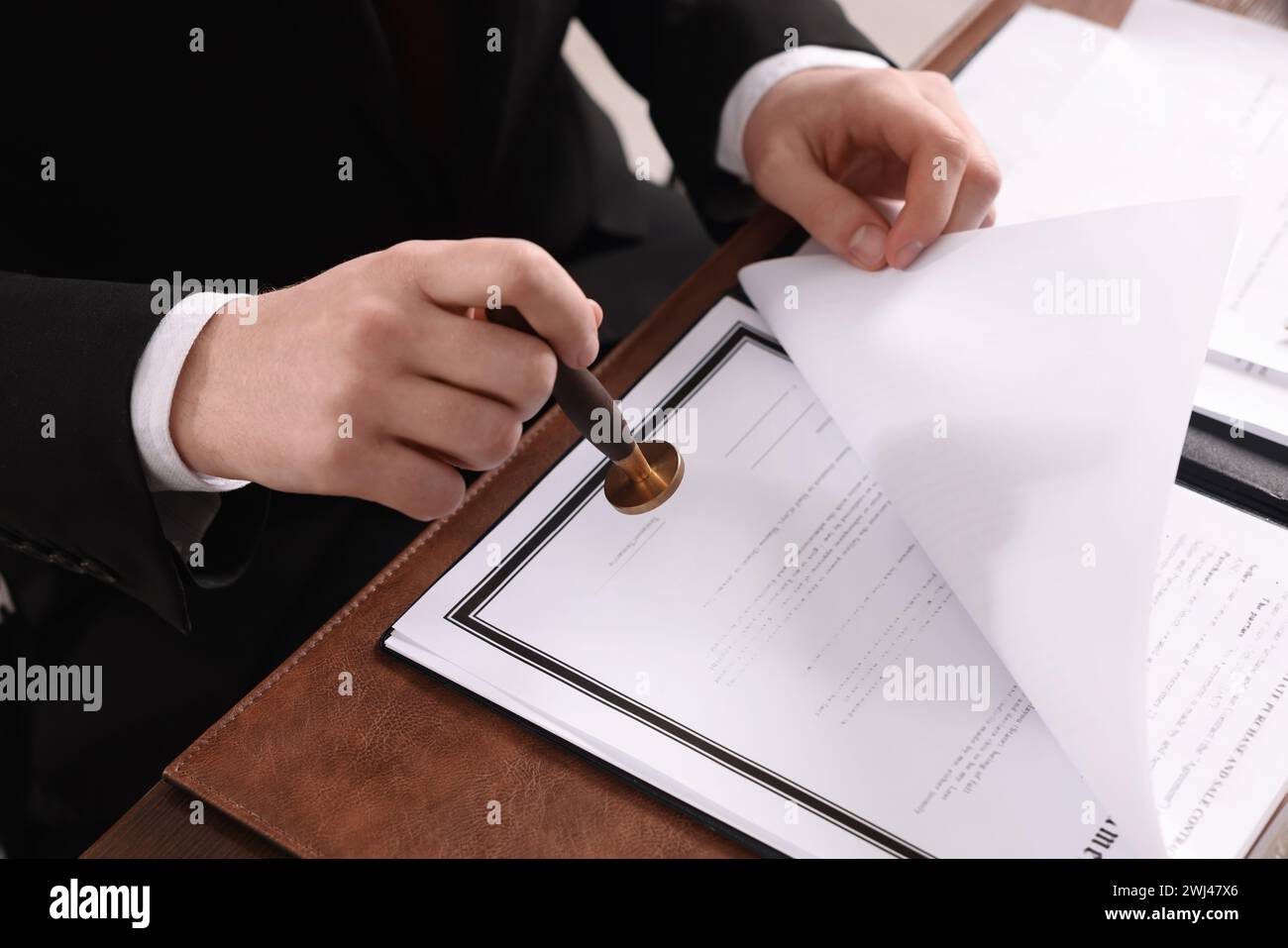 Notary stamping document at table in office, closeup Stock Photo - Alamy