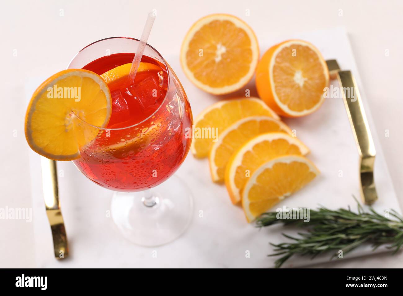 Glass of tasty Aperol spritz cocktail with orange slices and rosemary ...