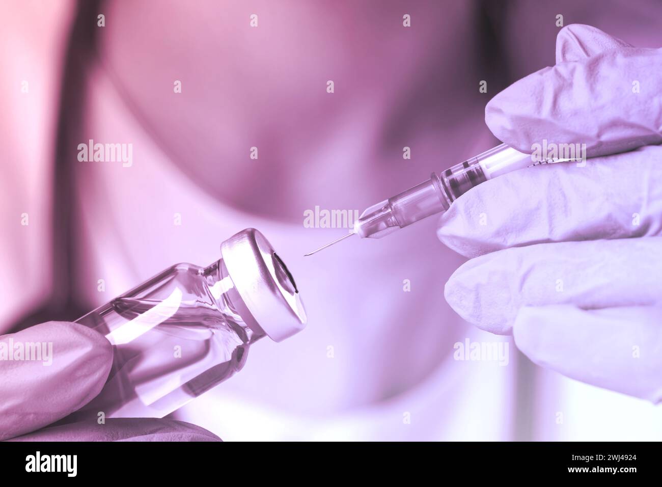 Doctor filling syringe with medication from vial, toned in pink Stock ...