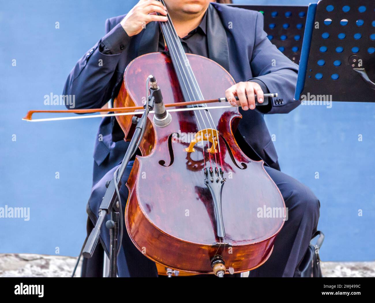 Musician in blue suit playing the cello Stock Photo - Alamy