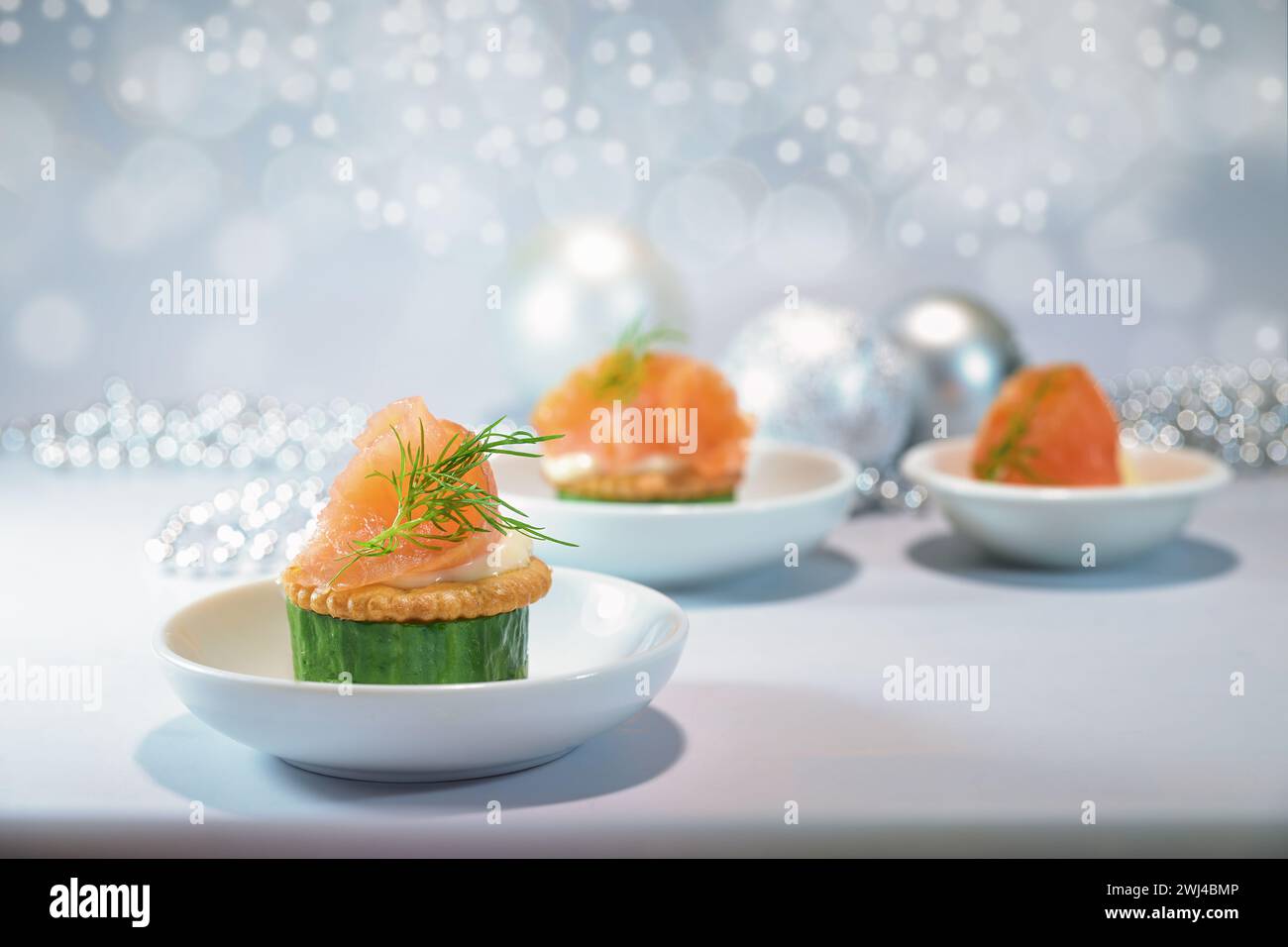 Smoked salmon on cucumber slices and crackers with dill garnish as ...
