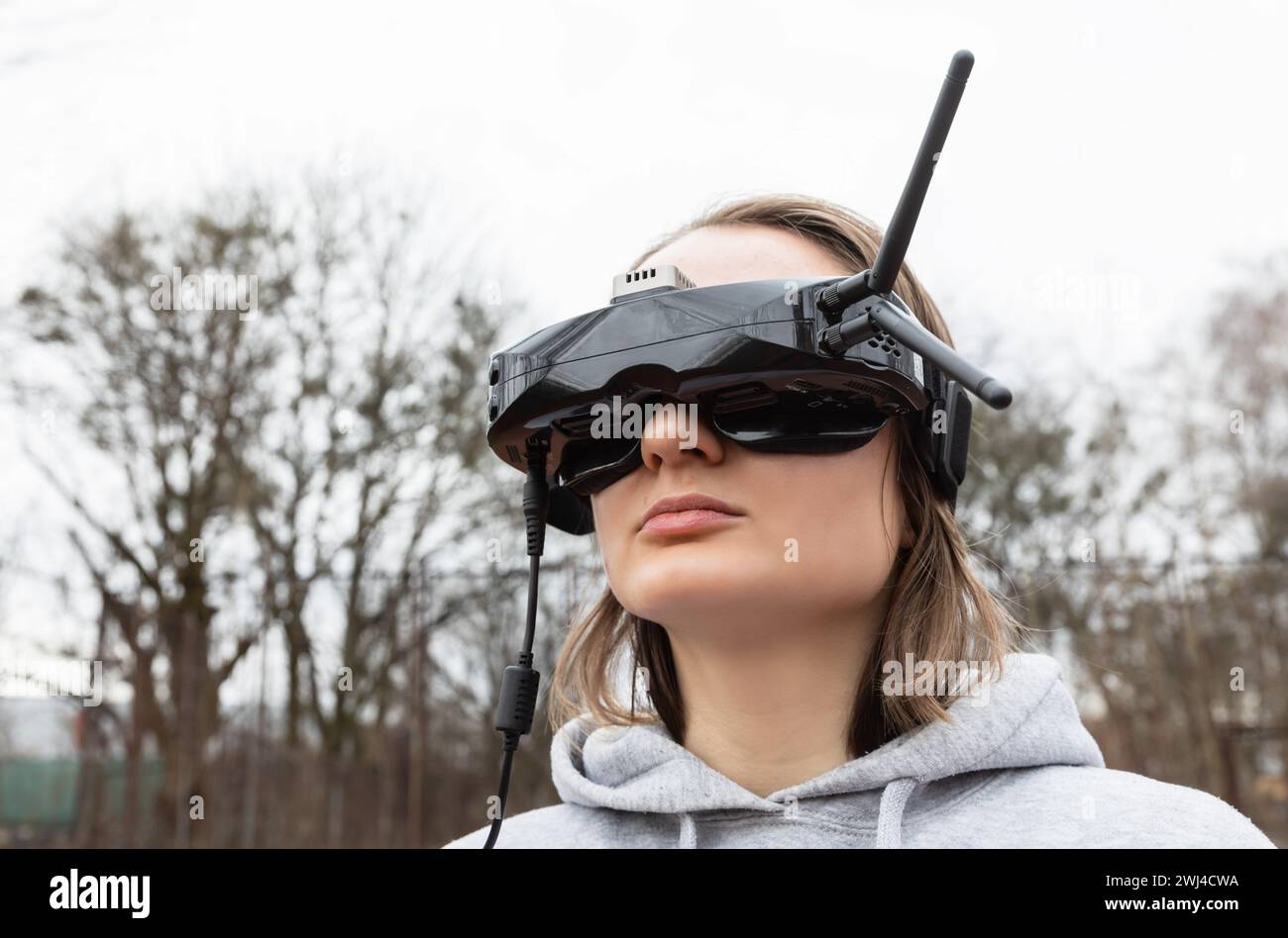 A young woman is seen wearing virtual reality goggles while learning to ...