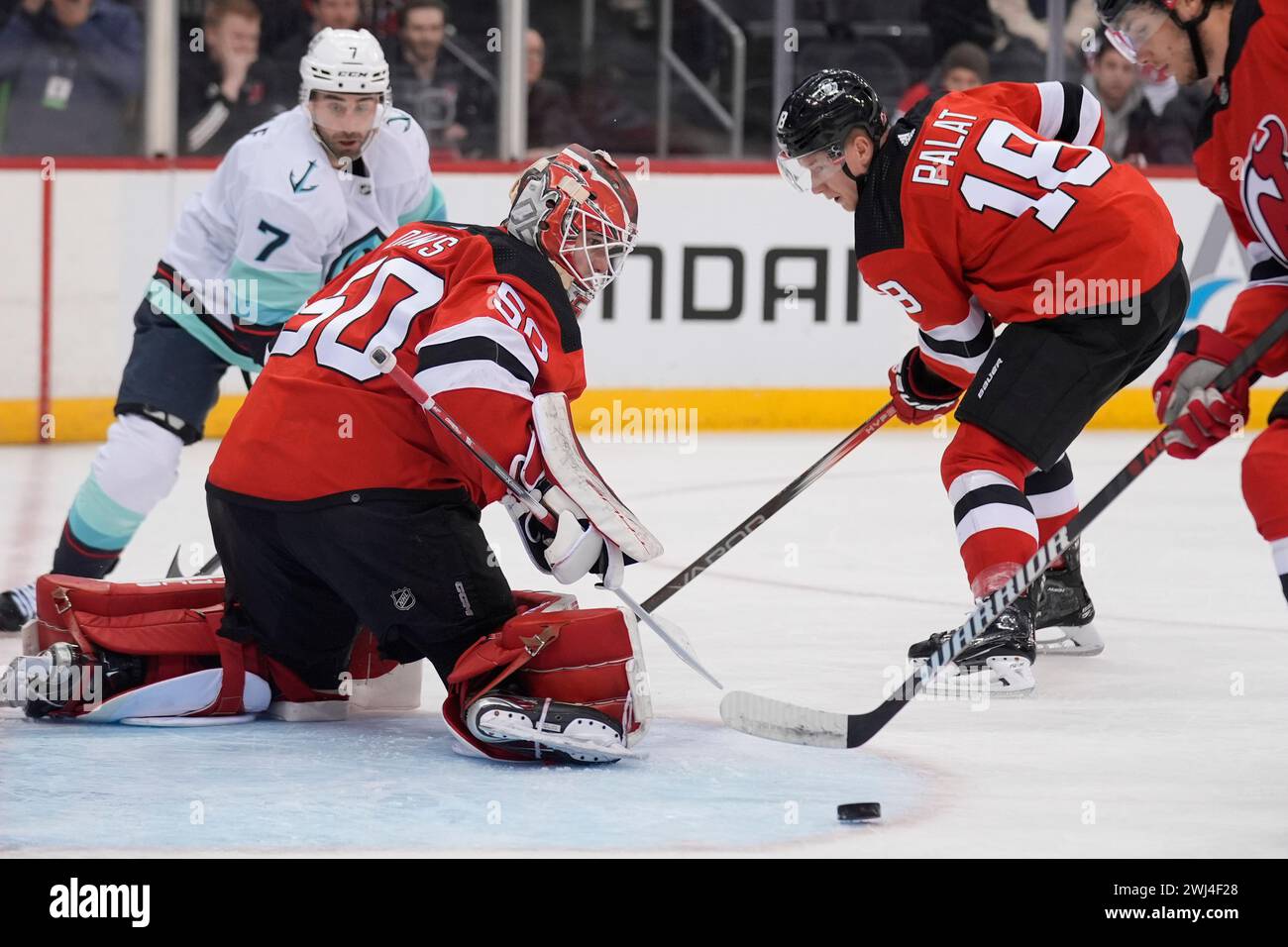 New Jersey Devils goaltender Nico Daws, second from left, makes a save ...