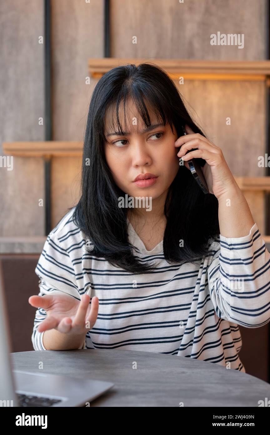 A serious, doubtful Asian woman is having a serious conversation on the ...