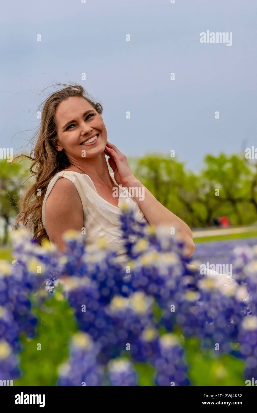 A Lovely Brunette Model Poses In A Field Of Bluebonnet Flowers In A ...
