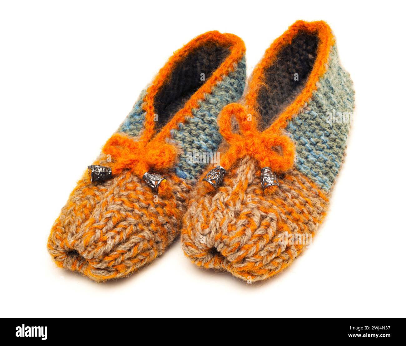 Colorful handmade knitted wool slippers stand on a white background ...