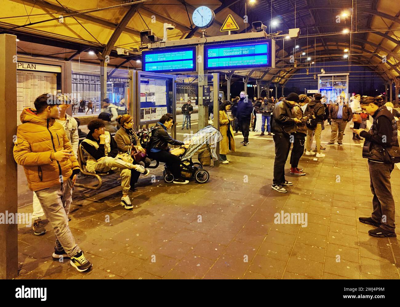 Menschen warten auf dem Bahnsteig am Abend auf den Zug, Hauptbahnhof, Krefeld, Nordrhein ...