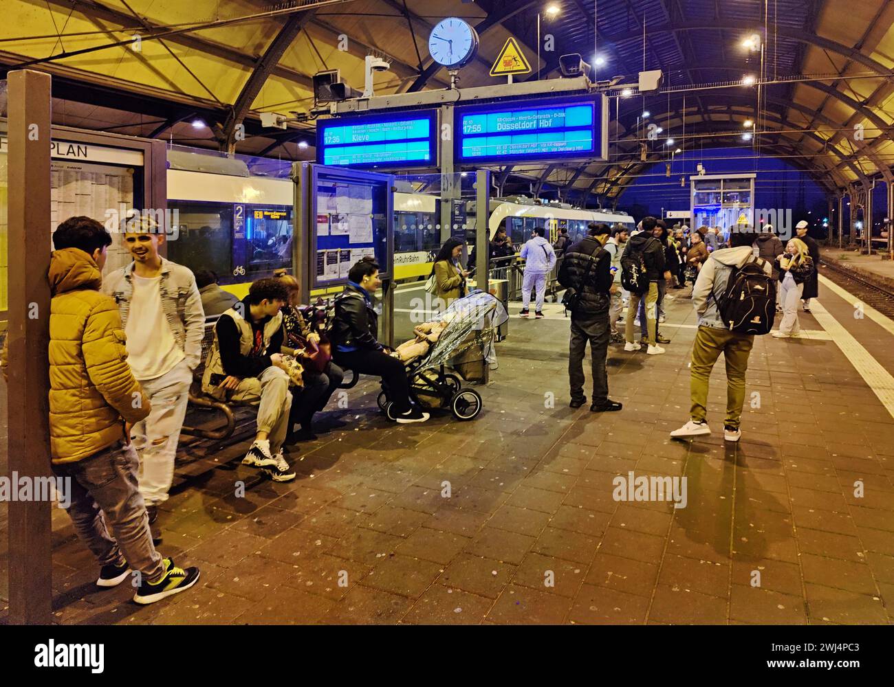 Menschen warten auf dem Bahnsteig am Abend auf den Zug, Hauptbahnhof, Krefeld, Nordrhein ...