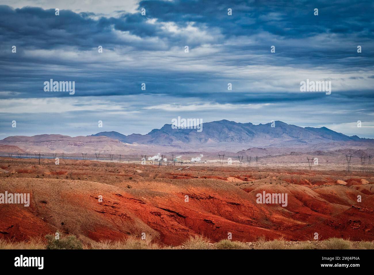 Desert landscape featuring distant mountains, power lines, and cloudy ...
