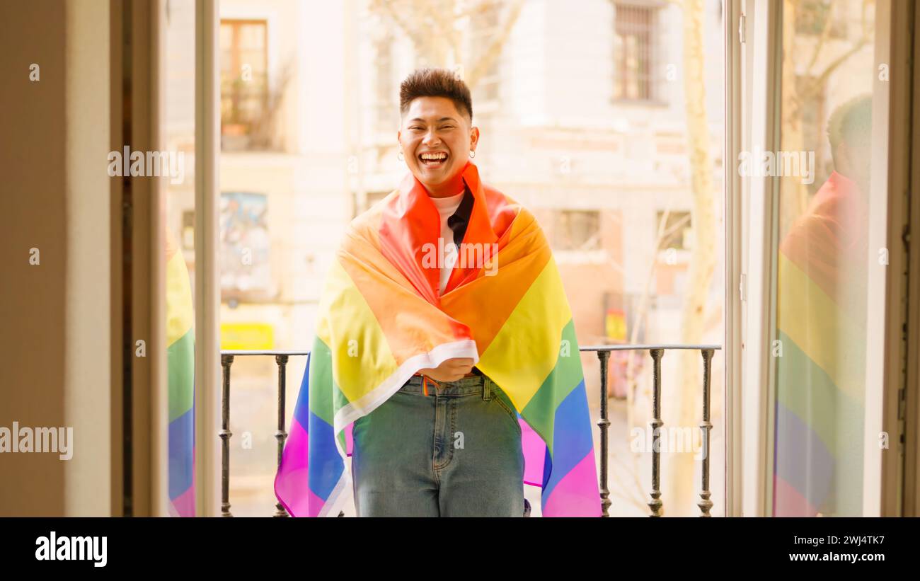 Hispanic man with a lgbt flag smiling Stock Photo - Alamy