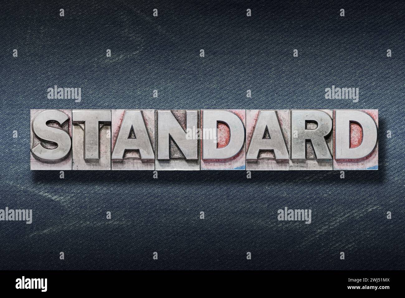 standard word made from metallic letterpress on dark jeans background ...