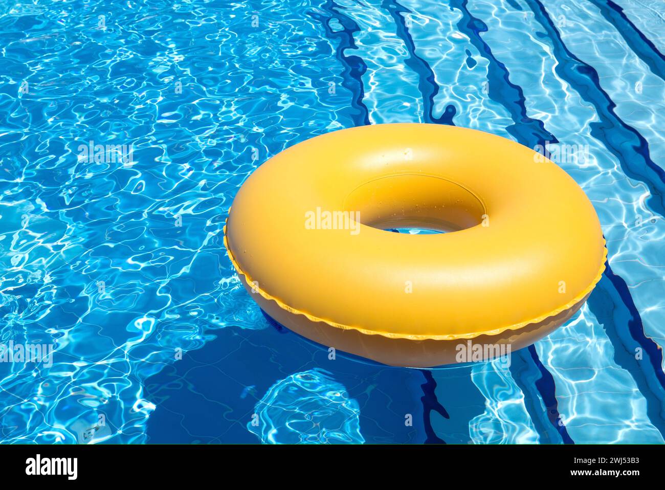 Inflatable yellow tube floating in clear blue waters Stock Photo - Alamy