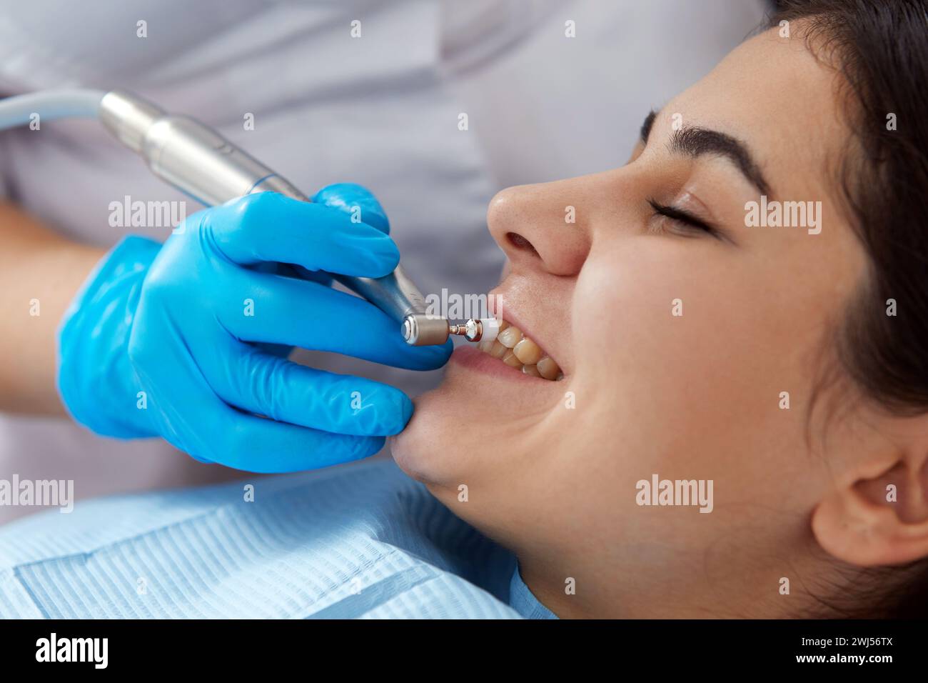Young woman getting her teeth polished in dental clinic. Professional ...