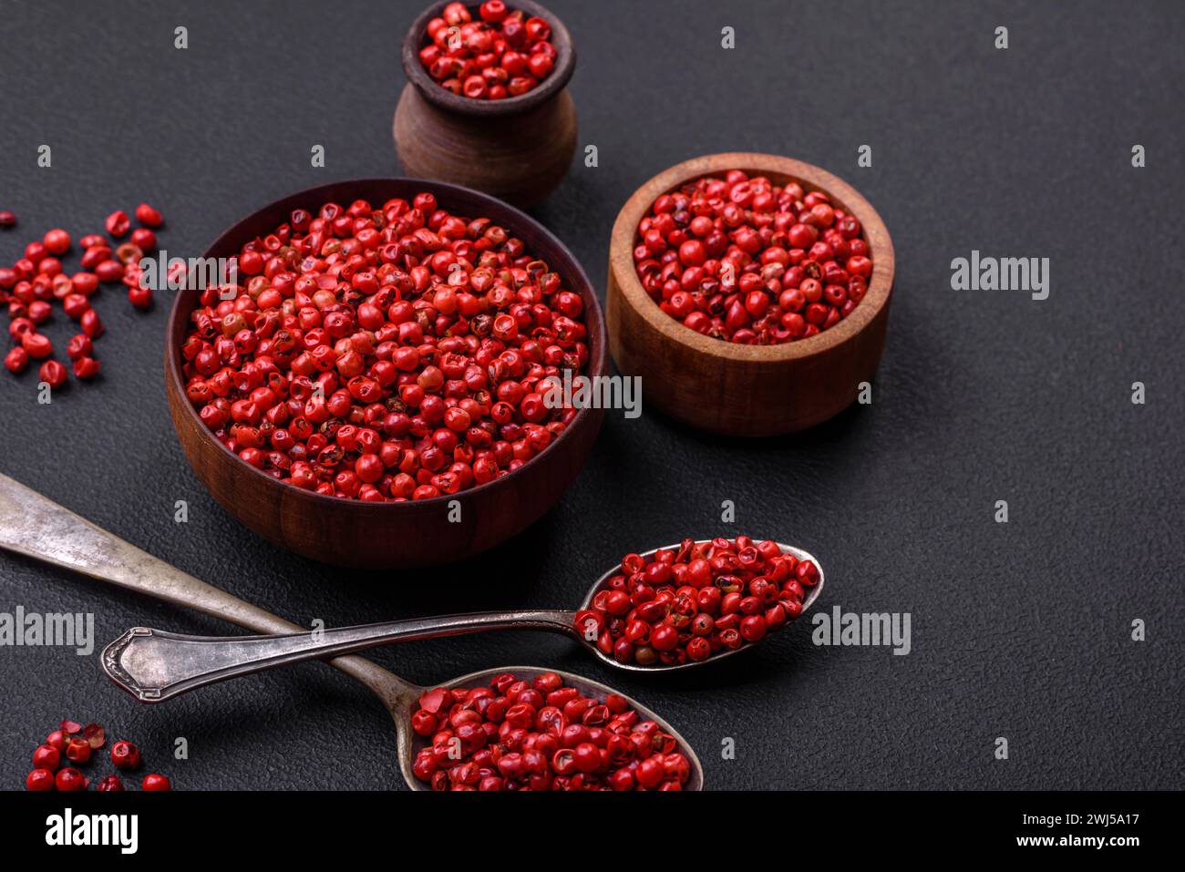 Spice, allspice peas of red or pink color in a wooden bowl Stock Photo ...