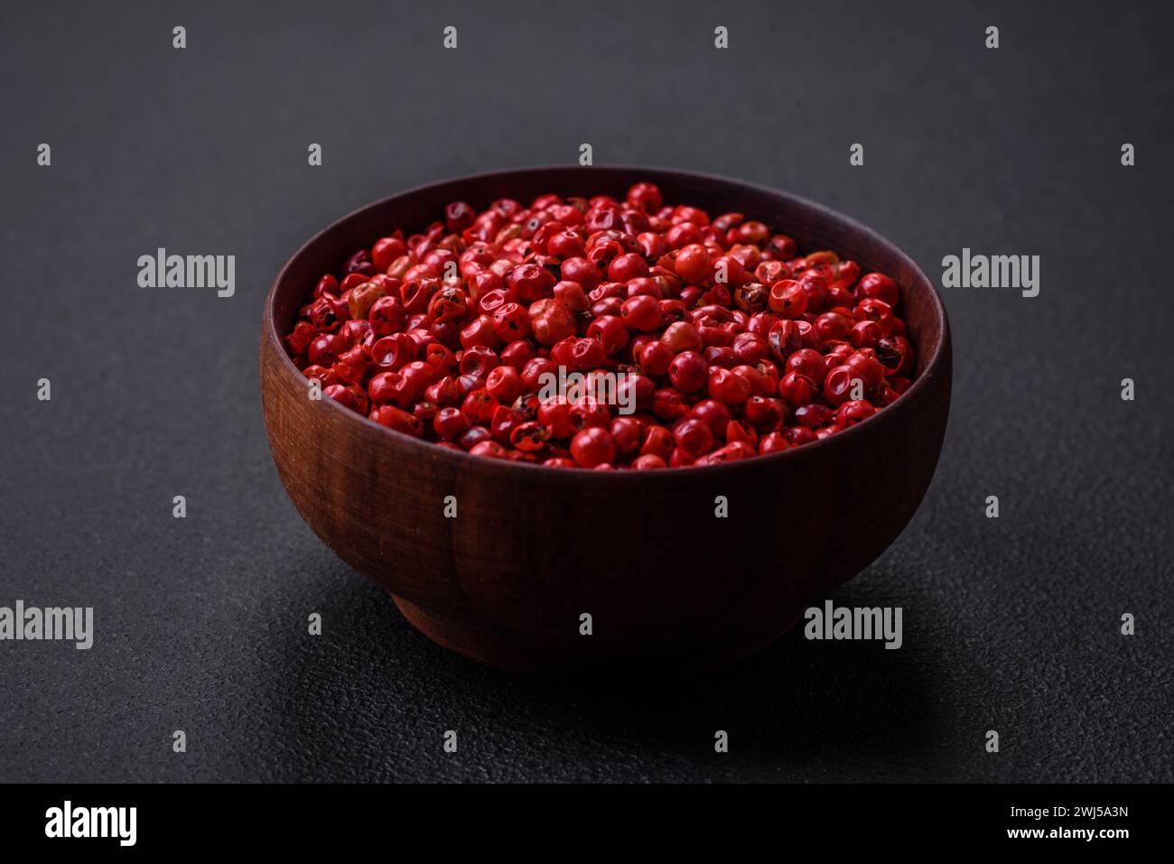 Spice, allspice peas of red or pink color in a wooden bowl Stock Photo ...