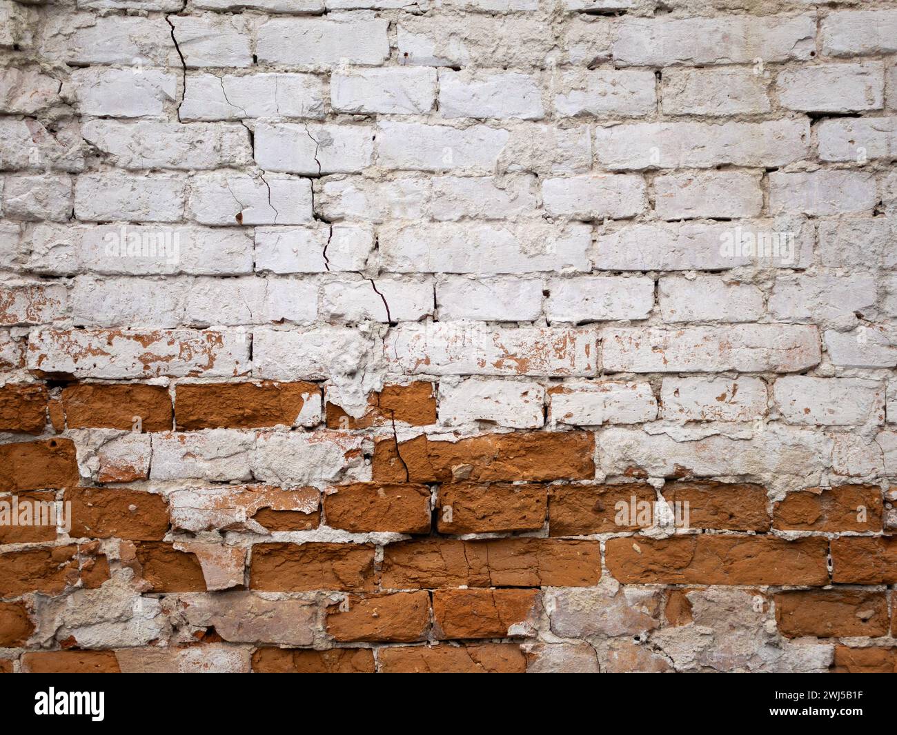 Old brick wall with peeling white paint and bricks crumbling from time ...