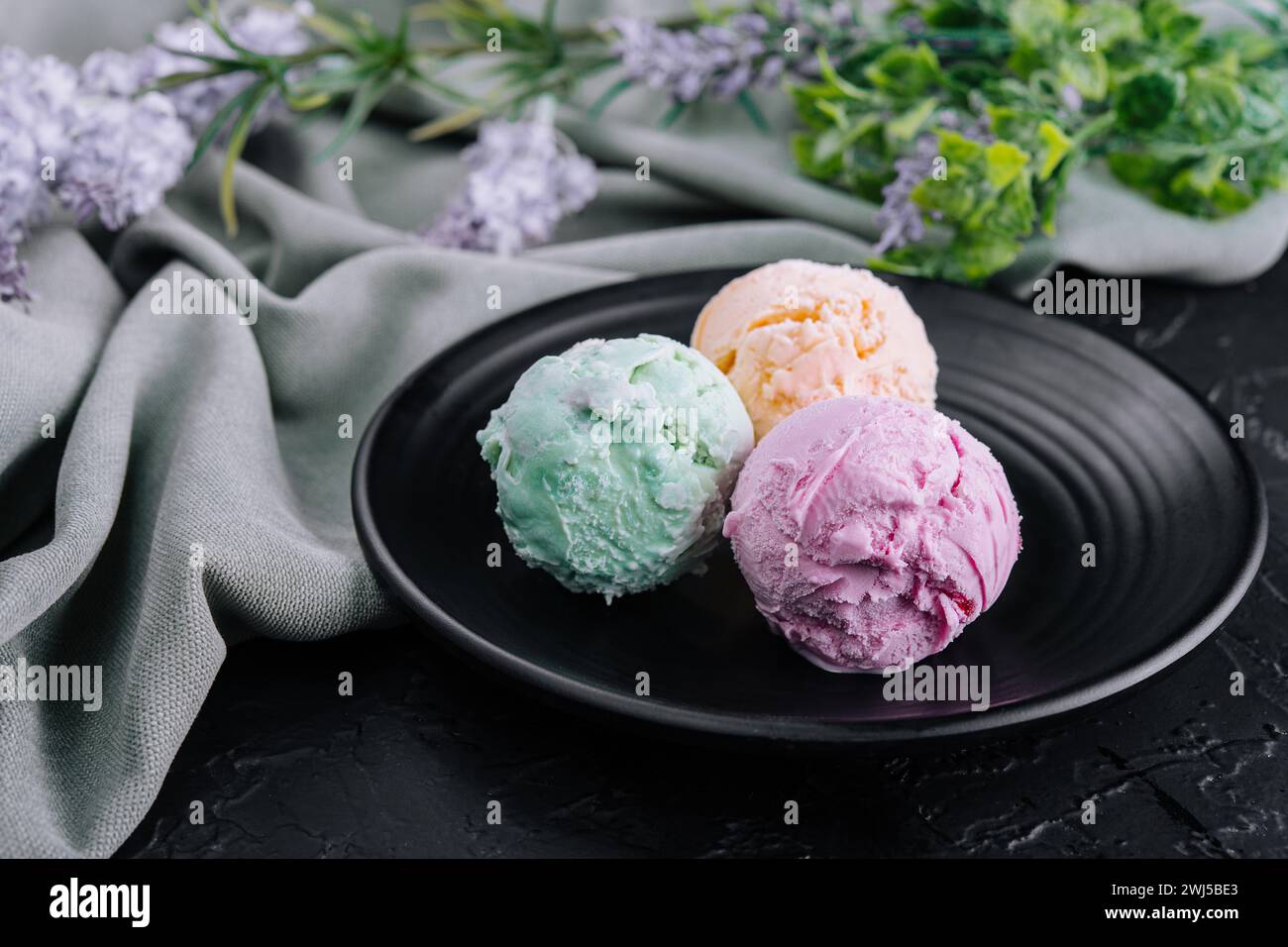 Three scoops of ice cream on dark plate Stock Photo - Alamy