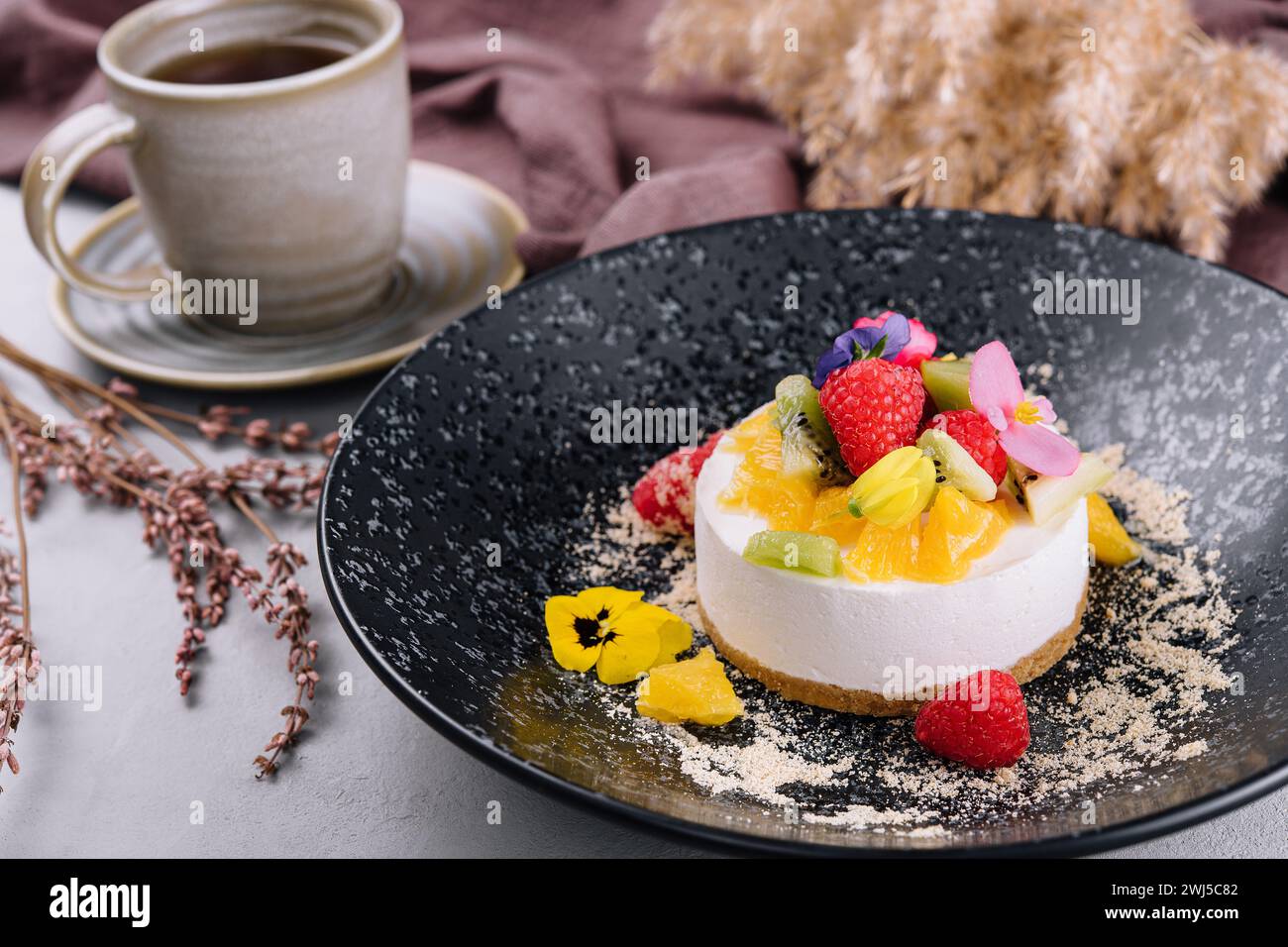 Round cheesecake with fruit decoration and cup of coffee Stock Photo ...