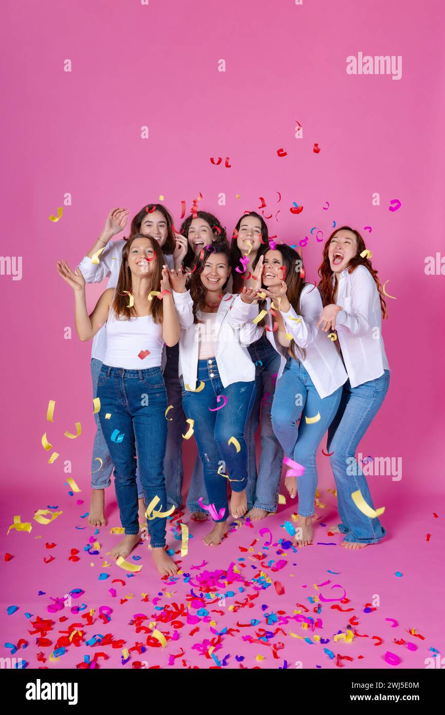 Group of jubilant friends celebrating with handfuls of colorful ...