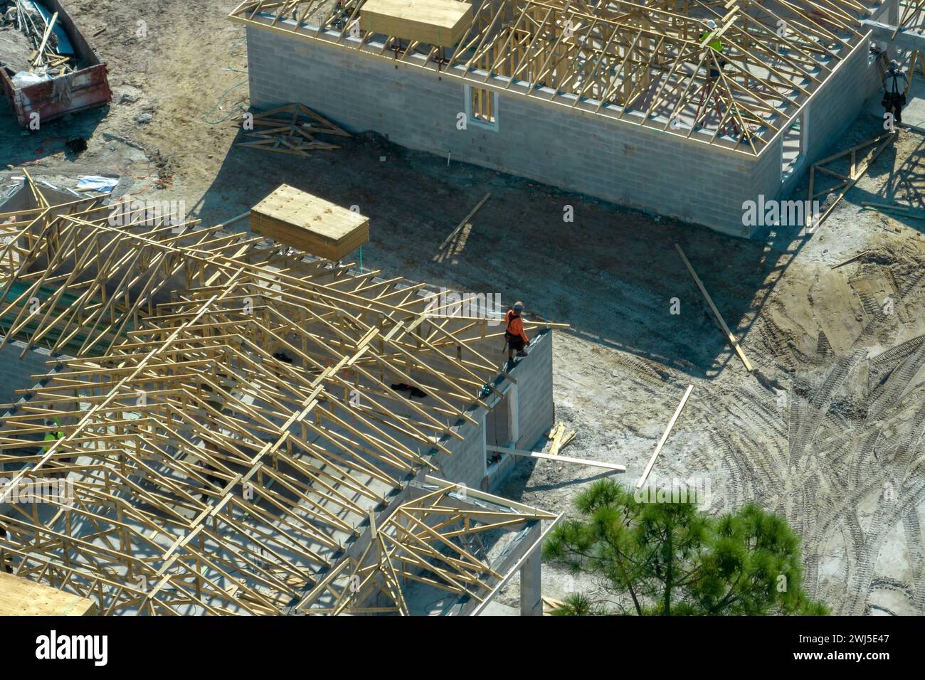 Builders working on roof construction of unfinished residential house ...