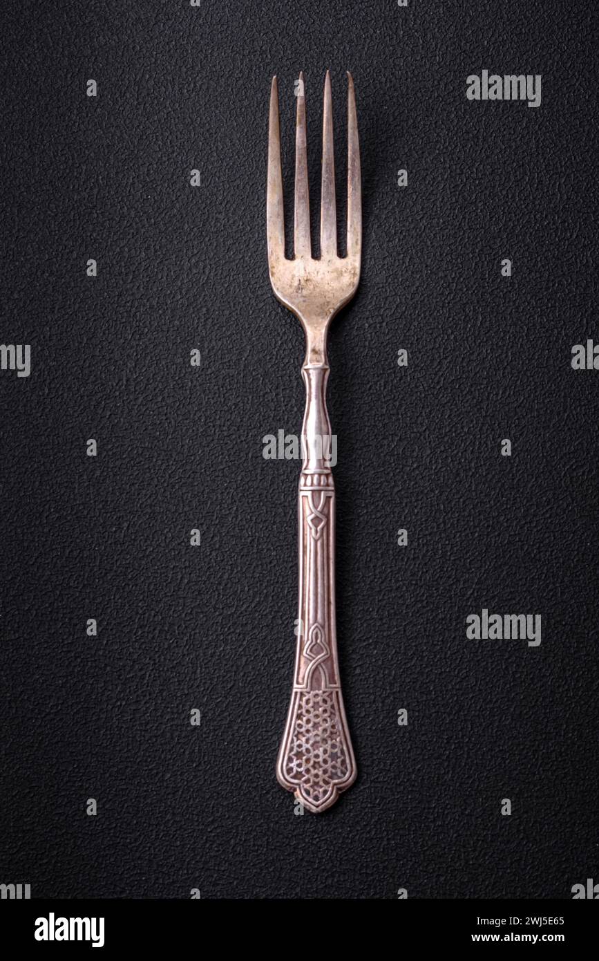 Metal kitchen fork on a dark textured concrete background Stock Photo ...